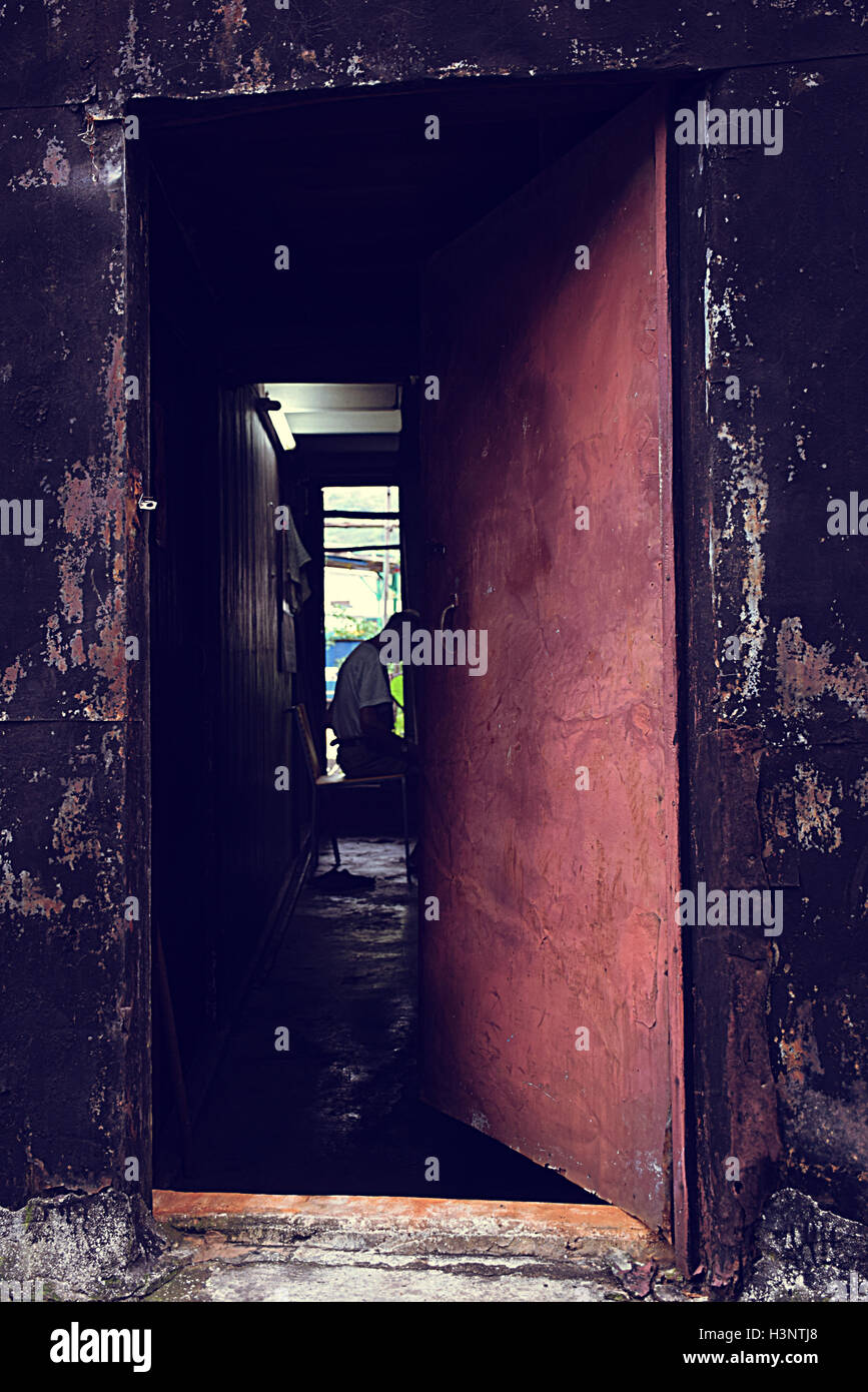 Old man working inside his old, rusted house in Tai O fishing village ...