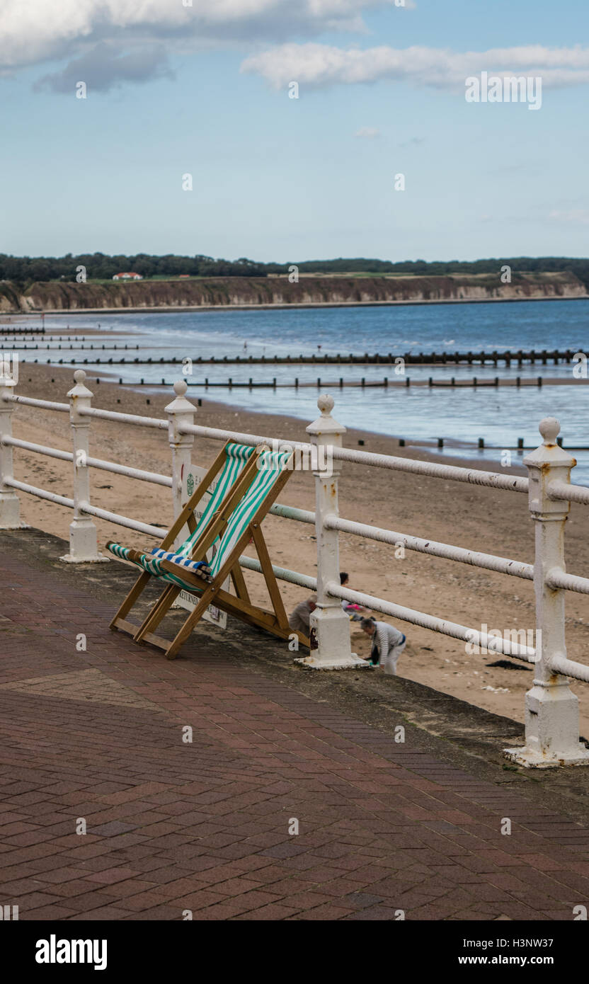 Empty wooden Deck chairs with green stripes on the seafront at ...