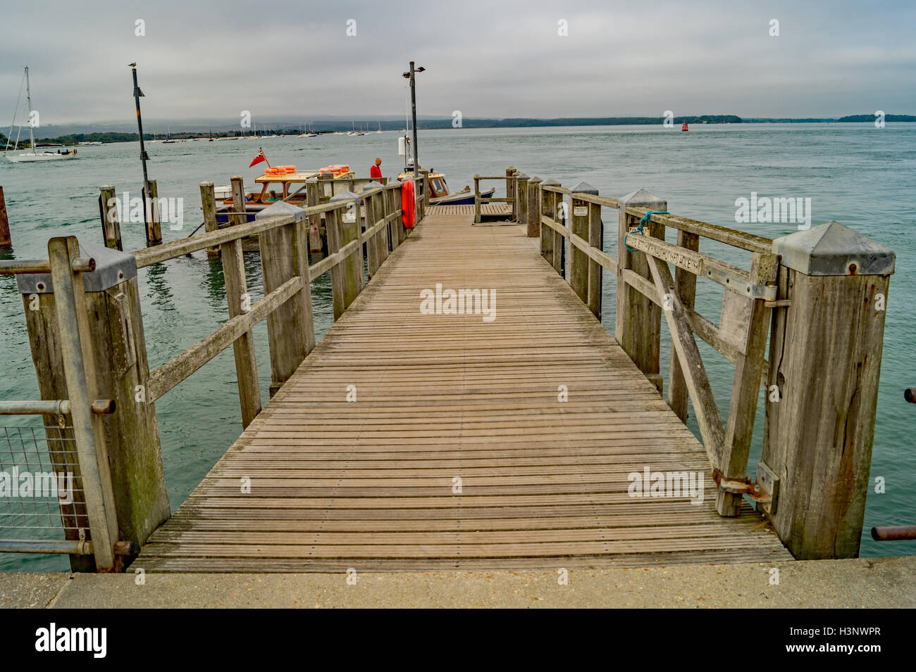 A view down a jetty to a waiting boat Stock Photo - Alamy