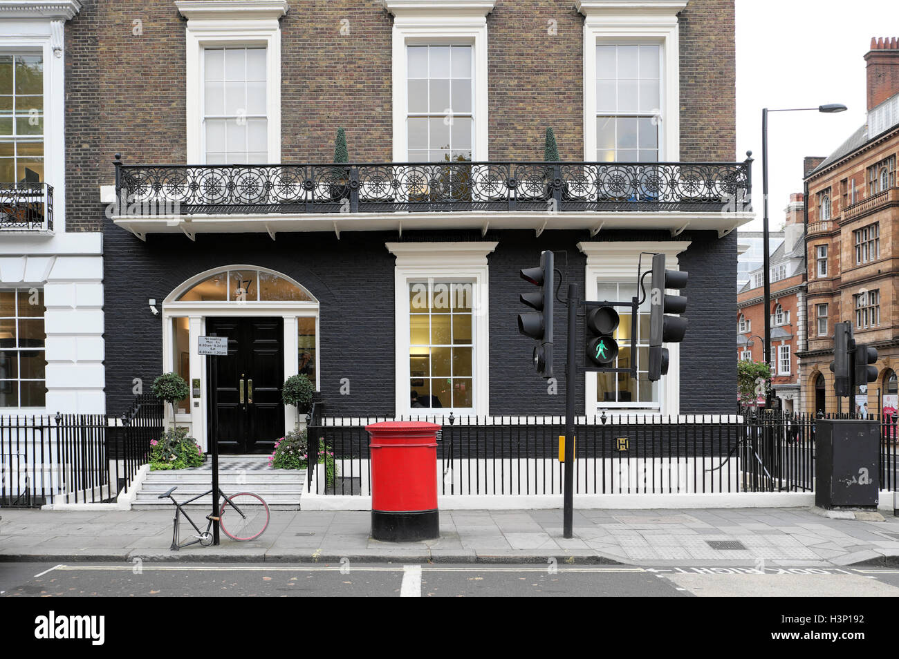 View of decorative railing, red postal box and office exterior on ...