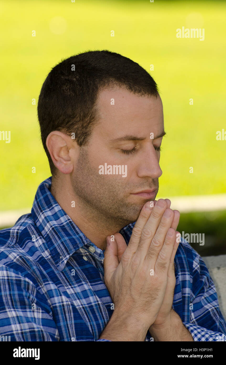 Man praying outdoors with a bright yellow sunlight background Stock ...