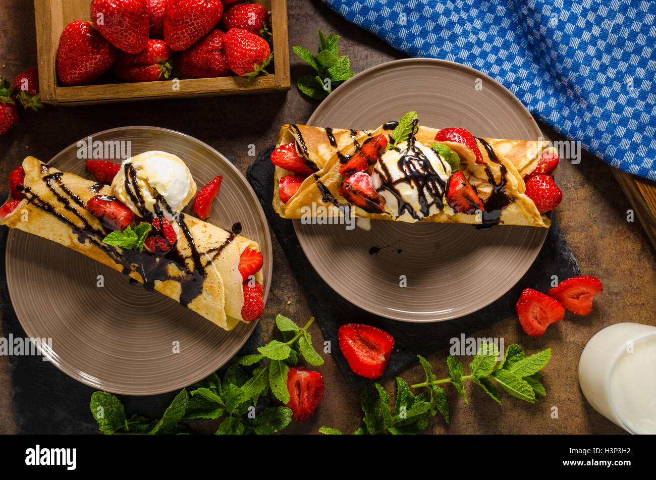 Crepes with ice cream, caramel topping and strawberries. Delicious ...