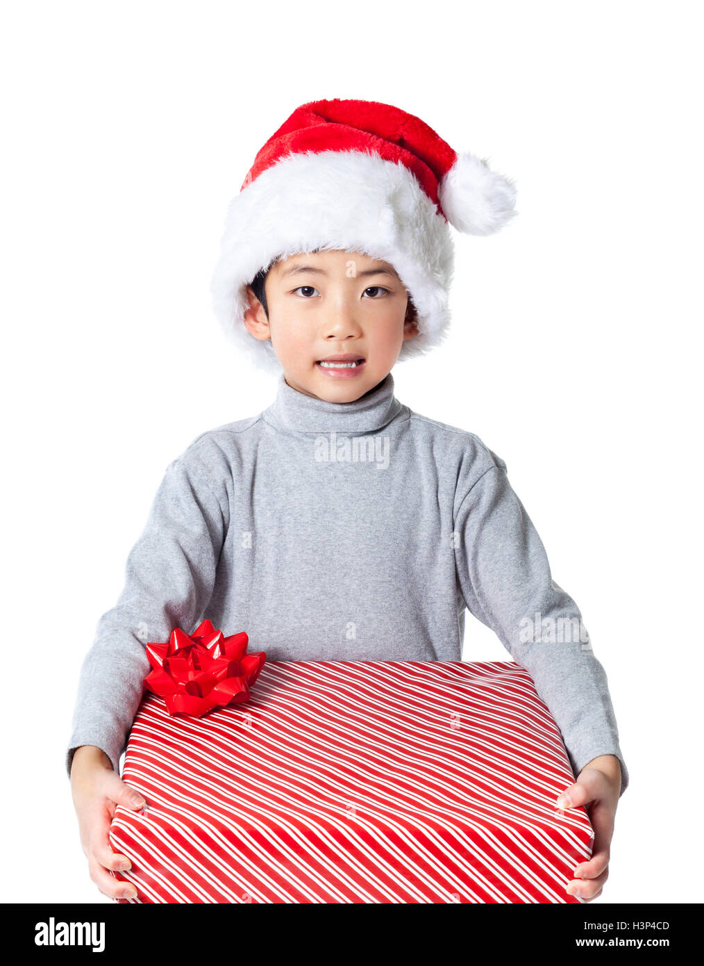 Cute Asian boy in Christmas mood wearing Santa Hat and carrying Xmas ...
