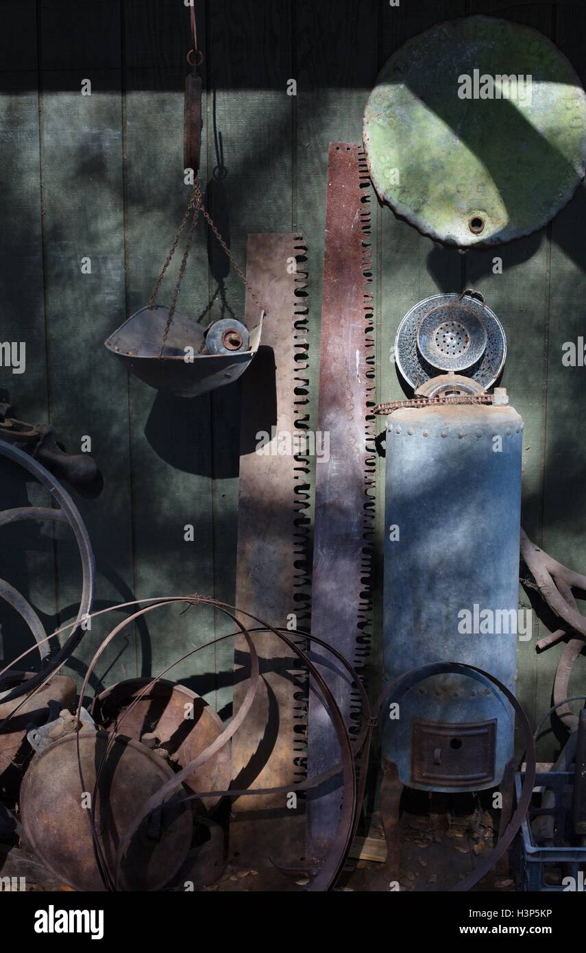 Rusty old antique tools and metal objects next to a rustic barn Stock ...