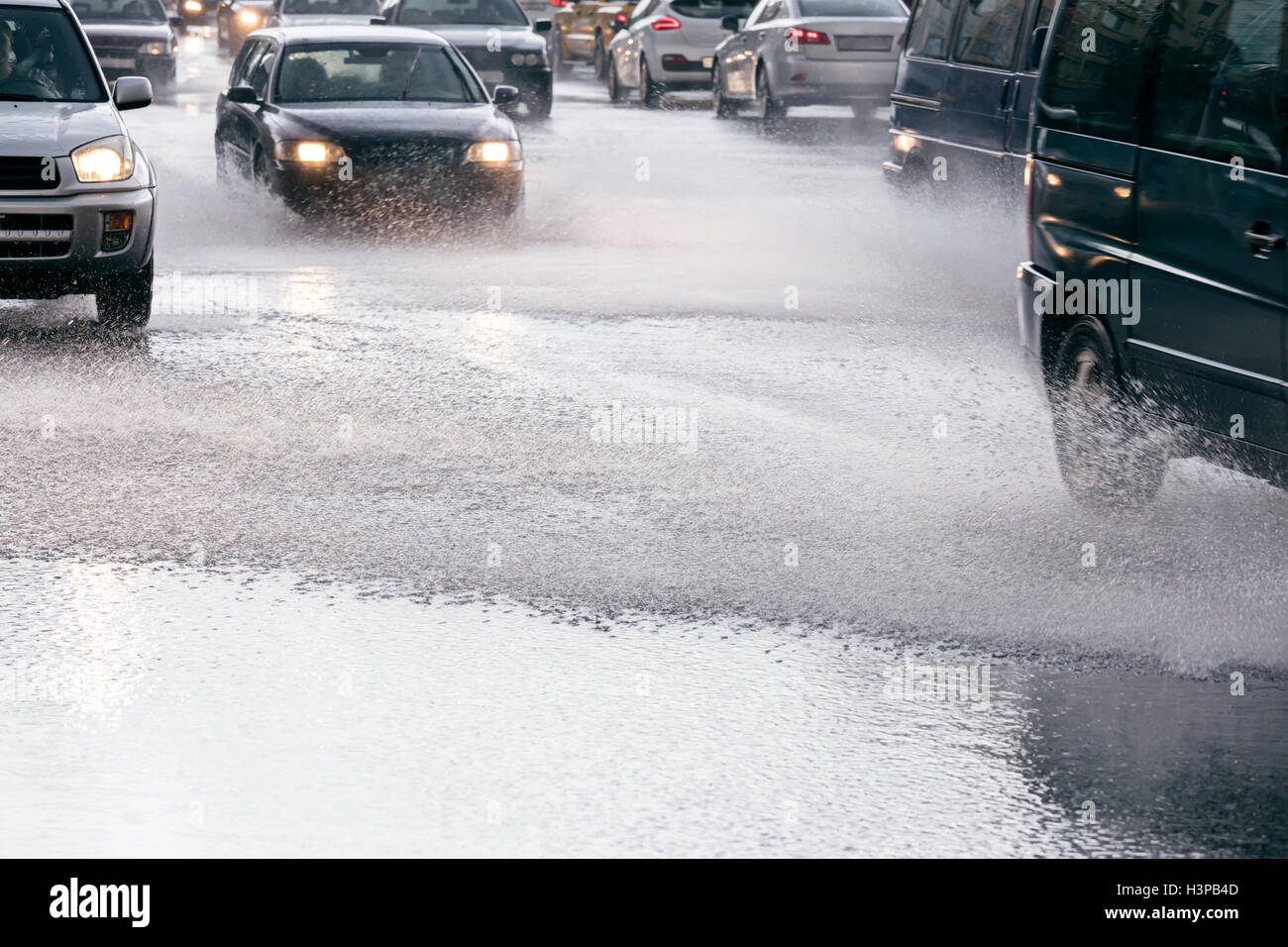 car traffic driving on flooded city road during rush hours in nasty ...