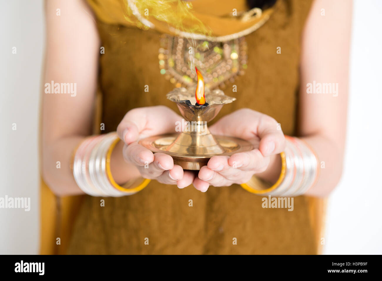 Close up fair Indian woman in traditional dress hands holding diya oil ...