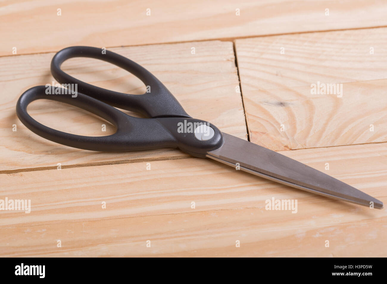 scissors isolated on a wood background Stock Photo - Alamy