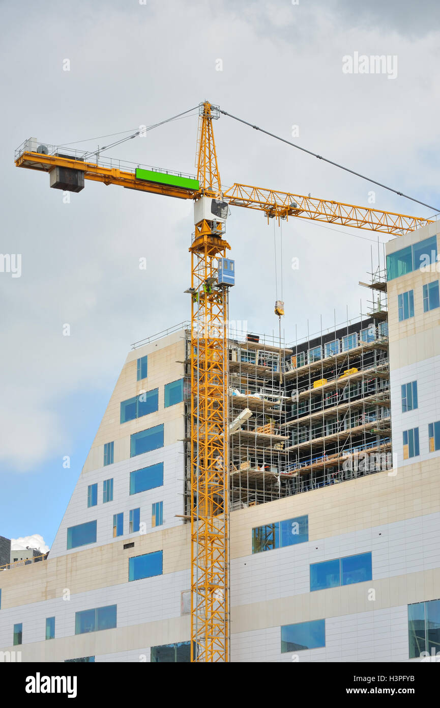 Working crane on a modern office building under construction Stock ...