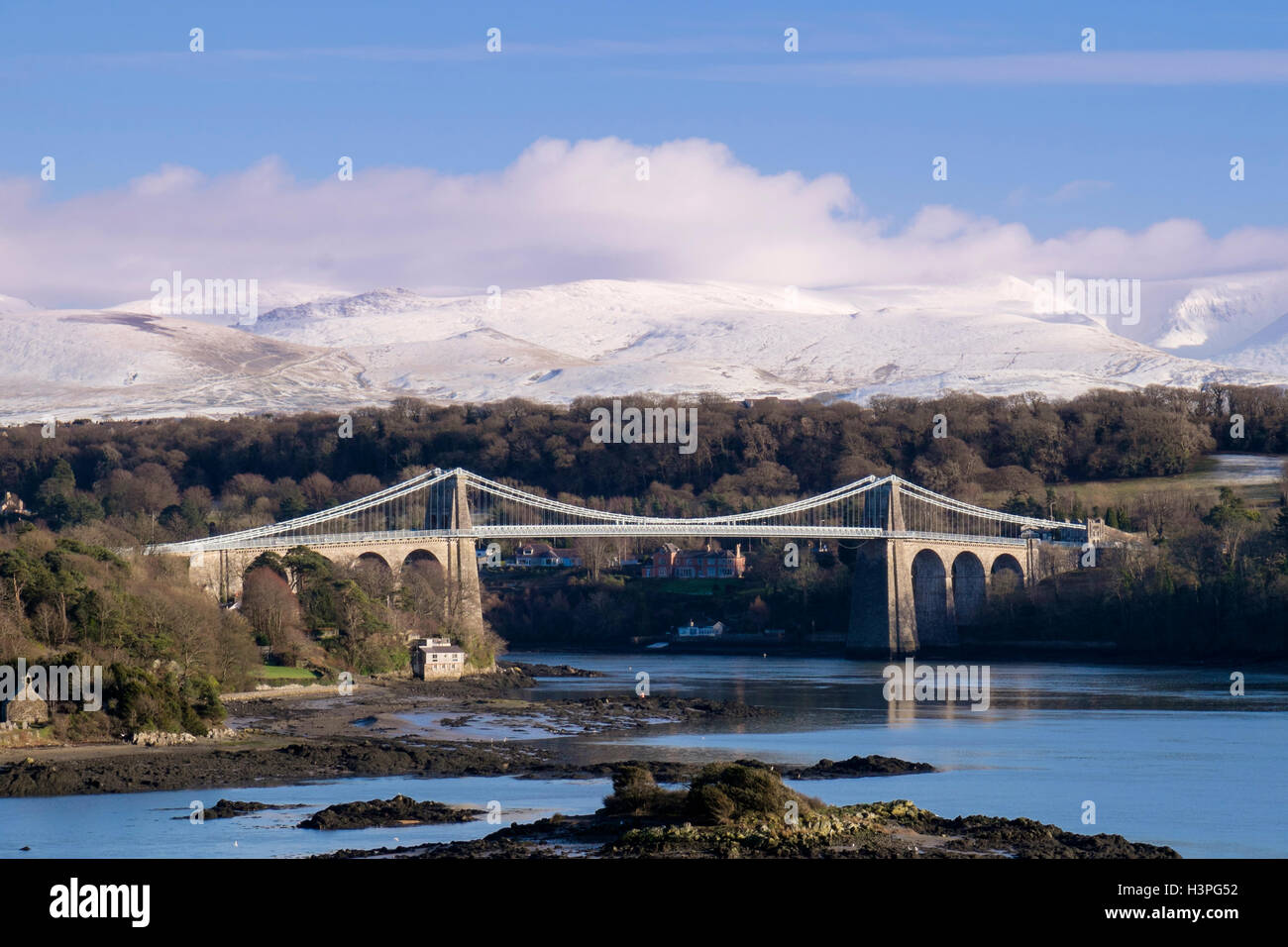 Menai Suspension Bridge across Menai Strait with snow on Carneddau ...