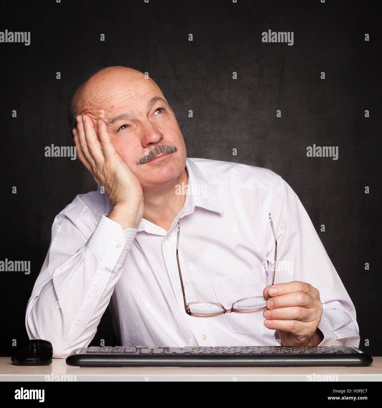 elderly man looking away thoughtfully, pondering the problem or task ...