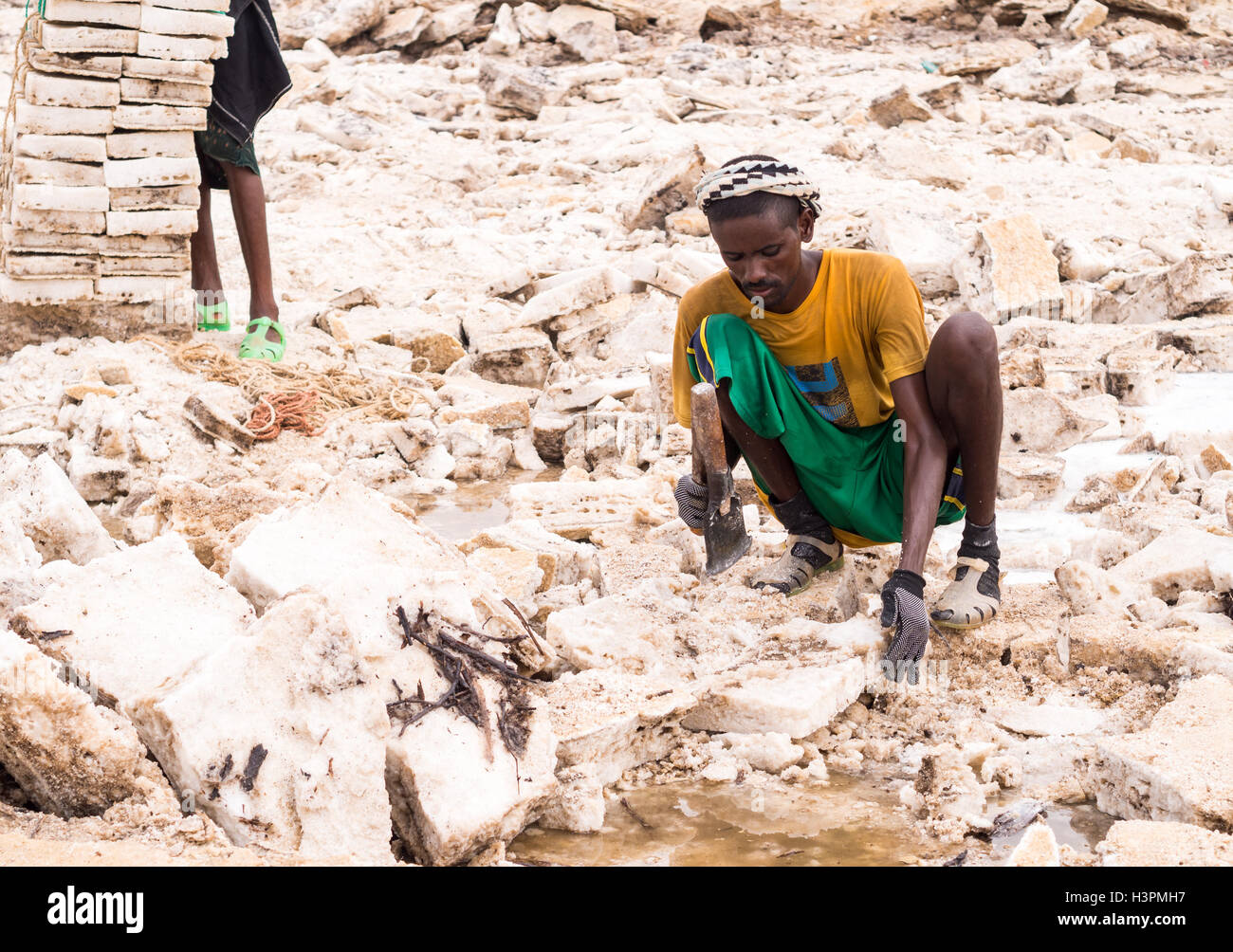 Afar man mining salt from salt flats in Afar region, Danakil Depression ...