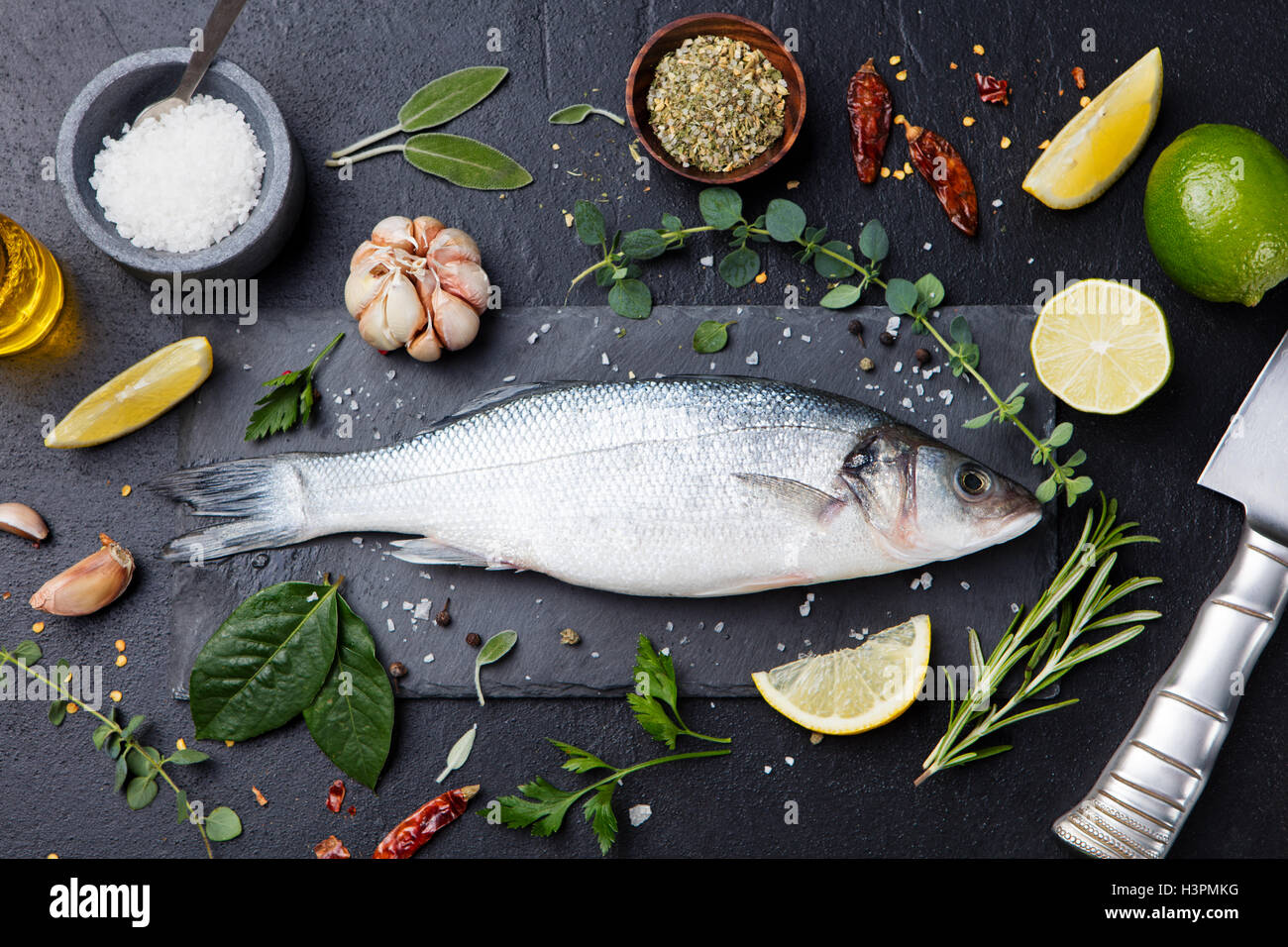 Raw fish, sea bass on slate black board Top view Stock Photo - Alamy