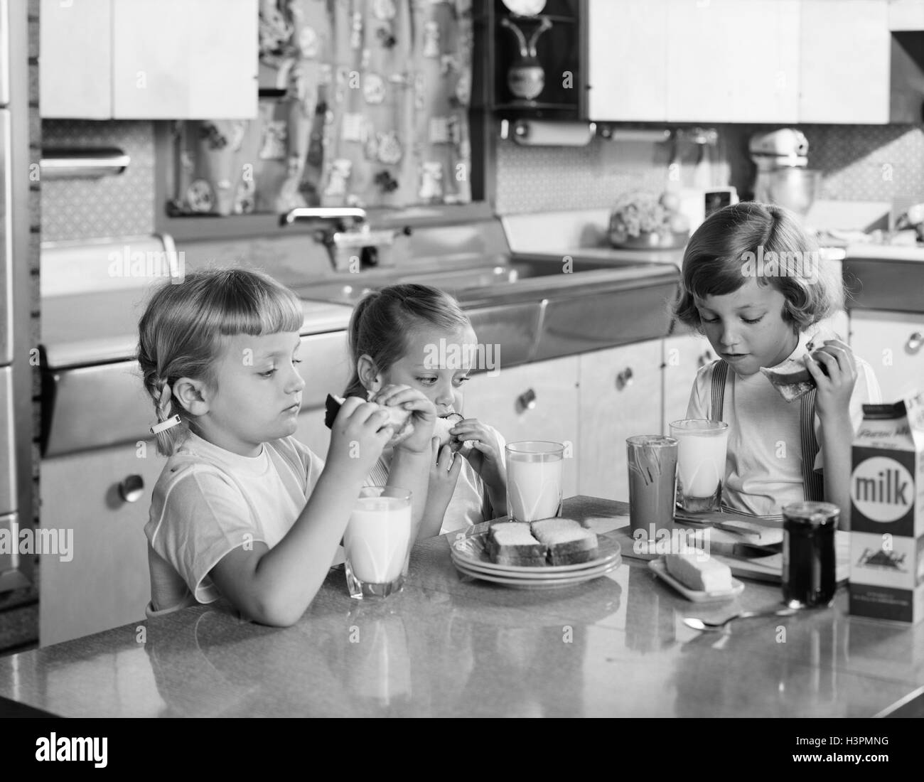 1950s THREE GIRLS SISTERS EATING LUNCH AT KITCHEN TABLE PEANUT BUTTER ...