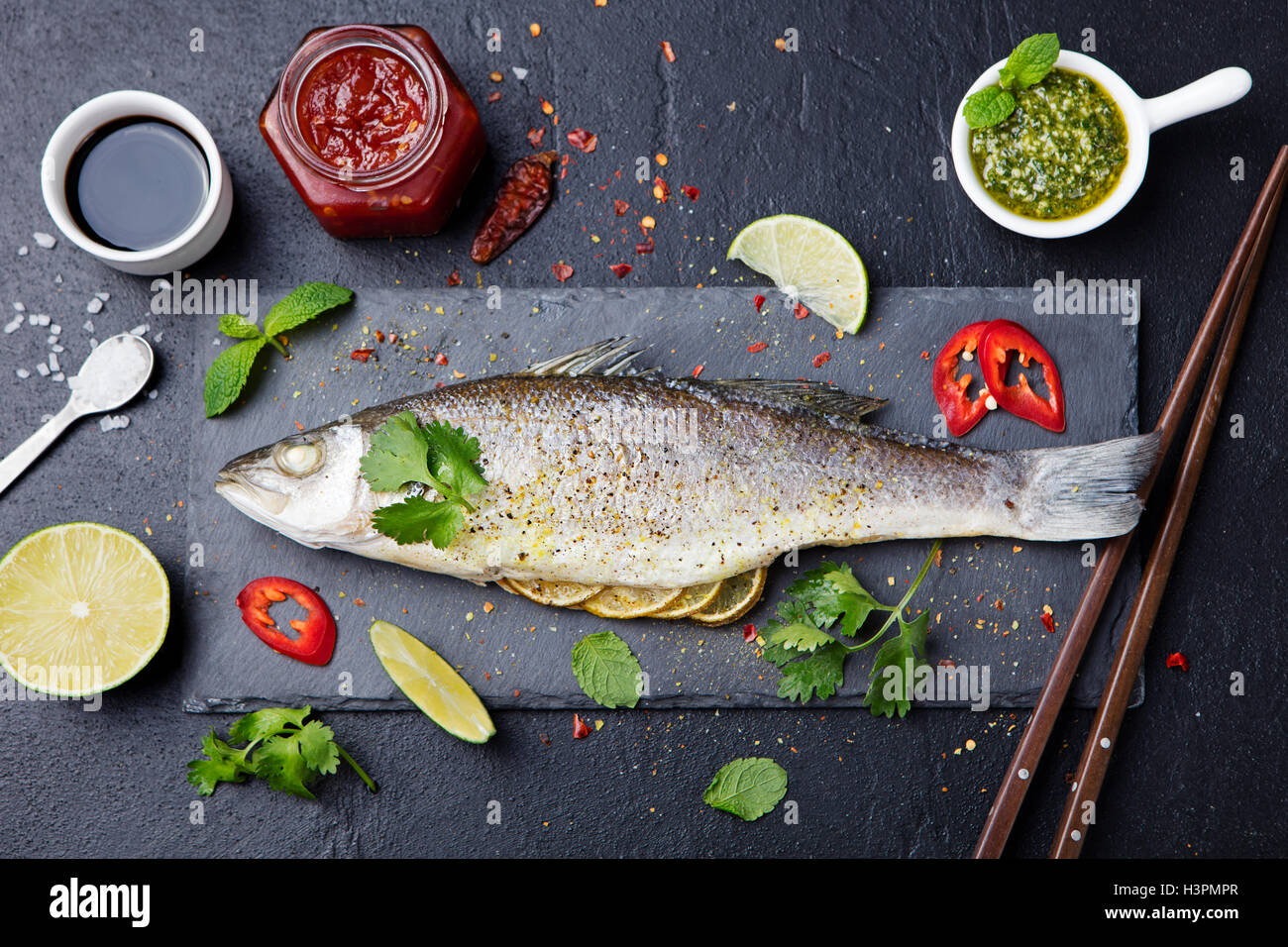Roasted fish with sauces, fresh herbs and lime Stock Photo - Alamy