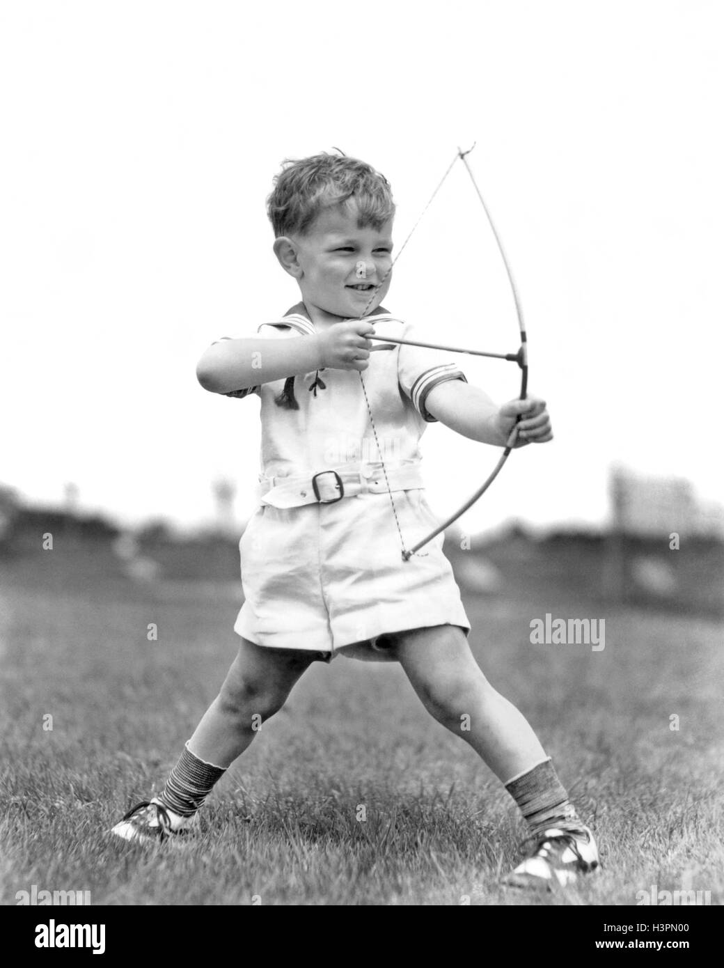 1930s BOY OUTDOORS AIMING TOY BOW AND ARROW ARCHERY Stock Photo - Alamy