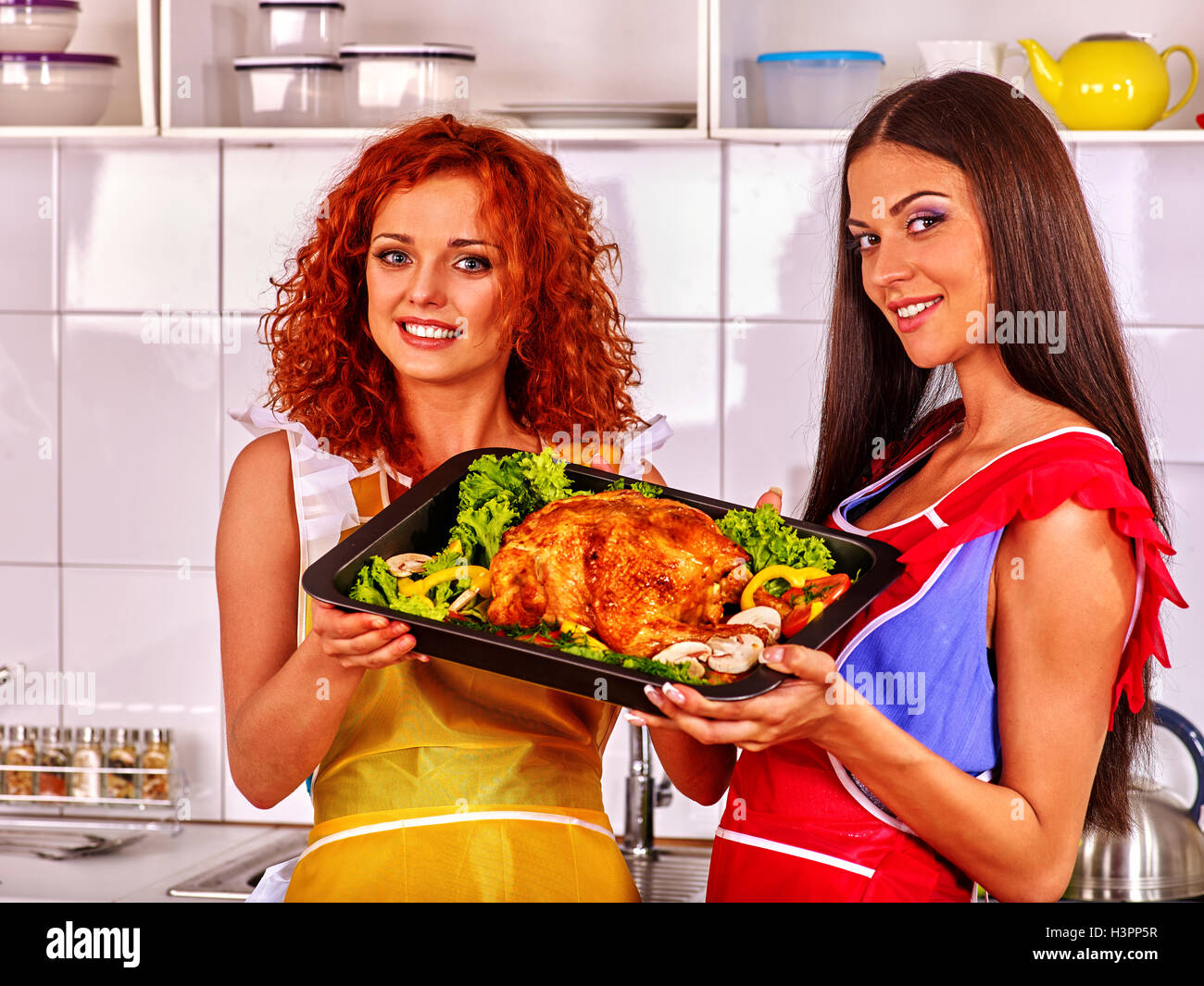 Girls together hold tray of fried chicken at kitchen Stock Photo - Alamy