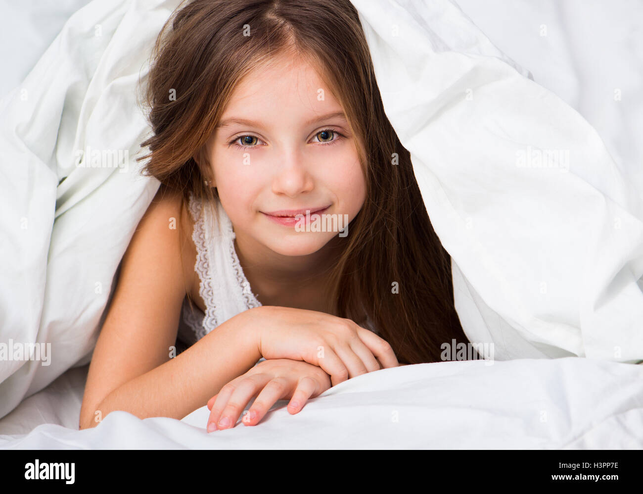 Beautiful little girl under a blanket Stock Photo - Alamy