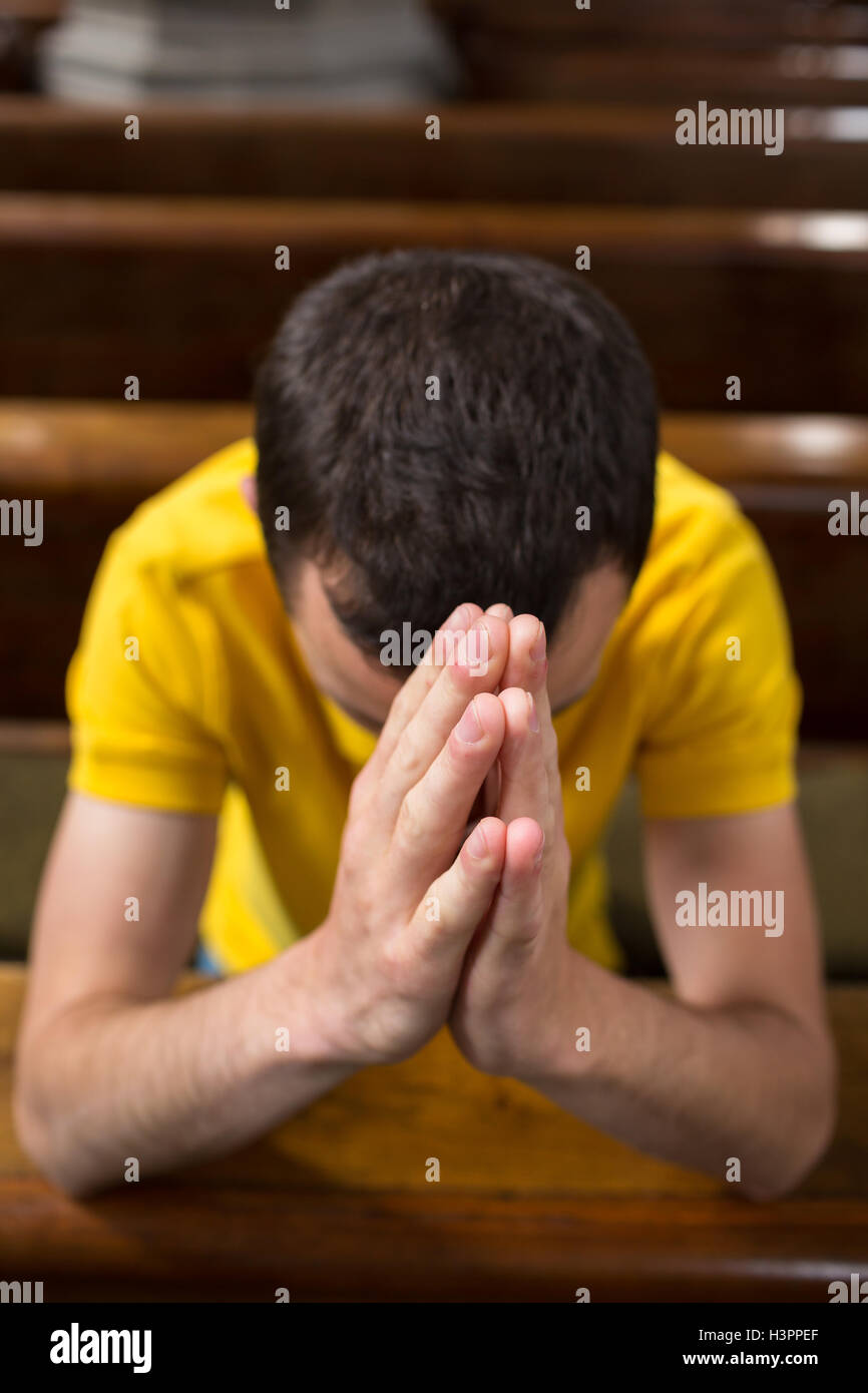Handsome young man praying in a church Stock Photo - Alamy