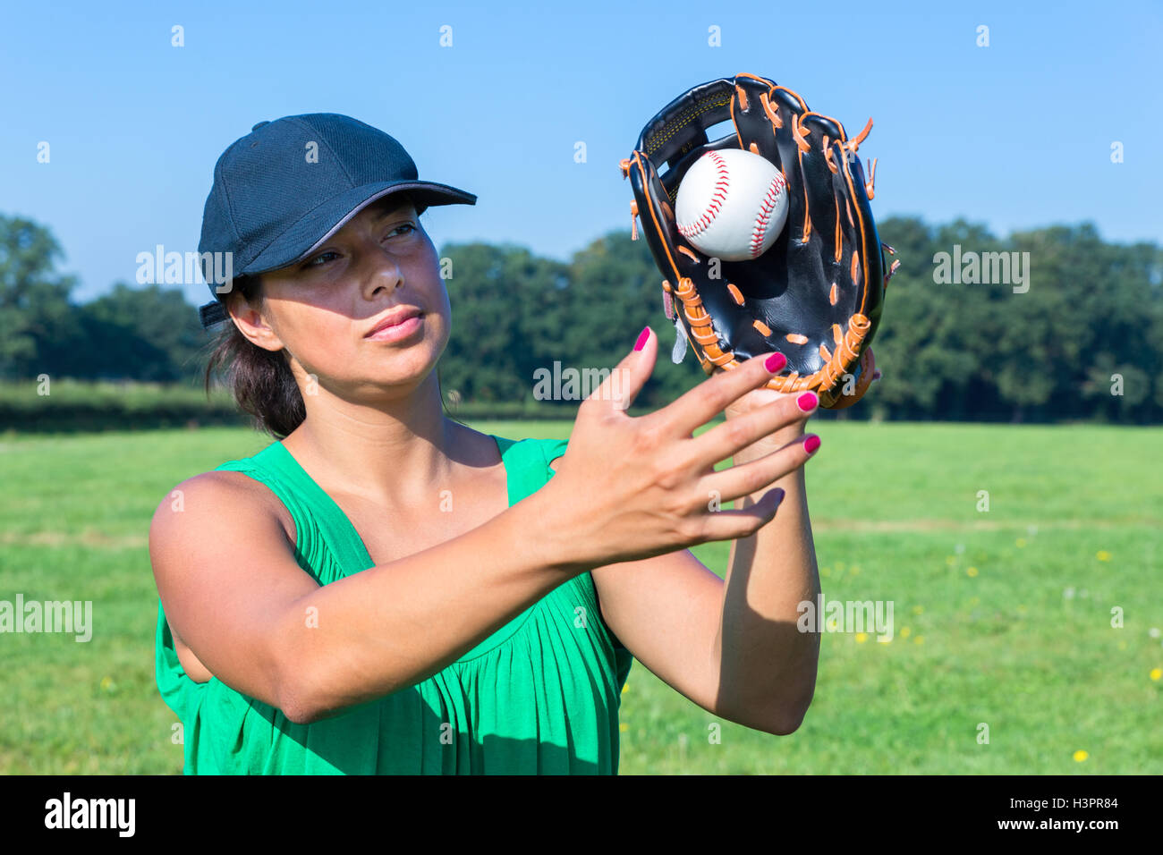 Woman with glove and cap catching baseball outdoors Stock Photo - Alamy