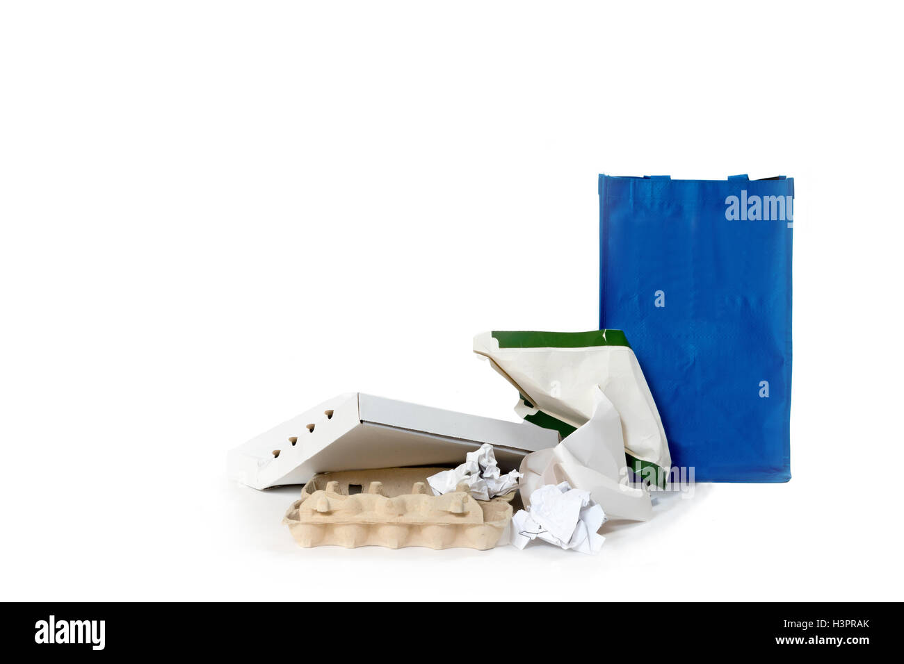 Pile of paper waste is lying on the white background. The empty blue ...