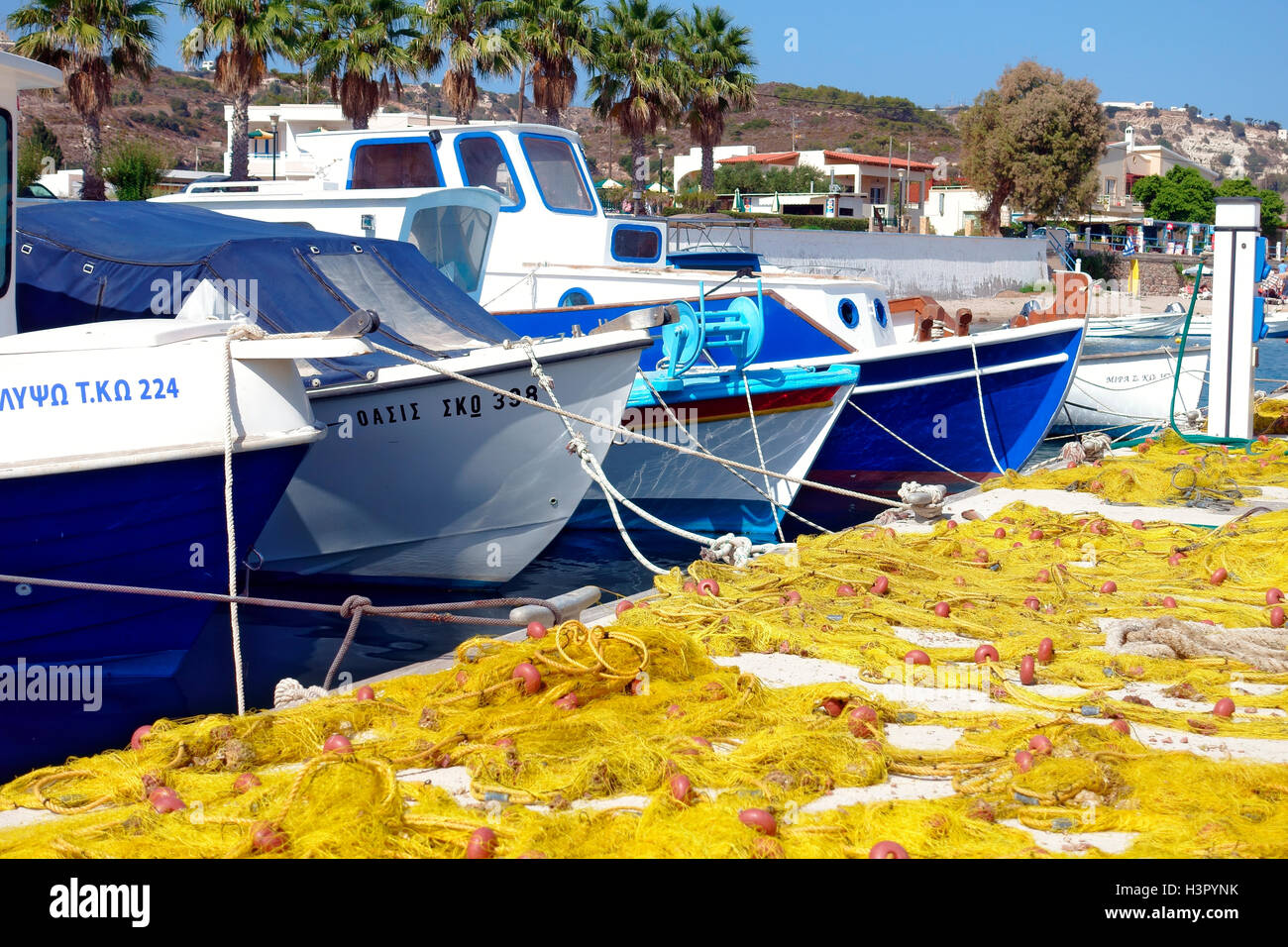 Brightly coloured fishing boats with nets drying at the harbour in ...