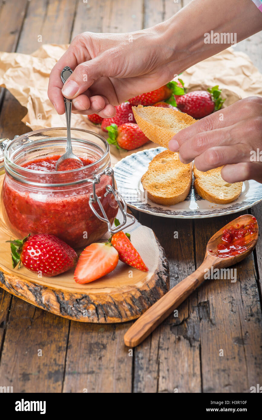 Smearing homemade strawberry jam on a toast for breakfast Stock Photo ...