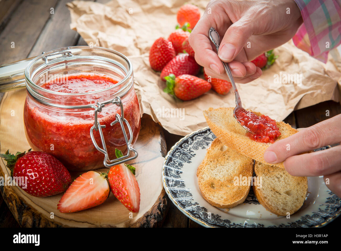Smearing homemade strawberry jam on a toast for breakfast Stock Photo ...