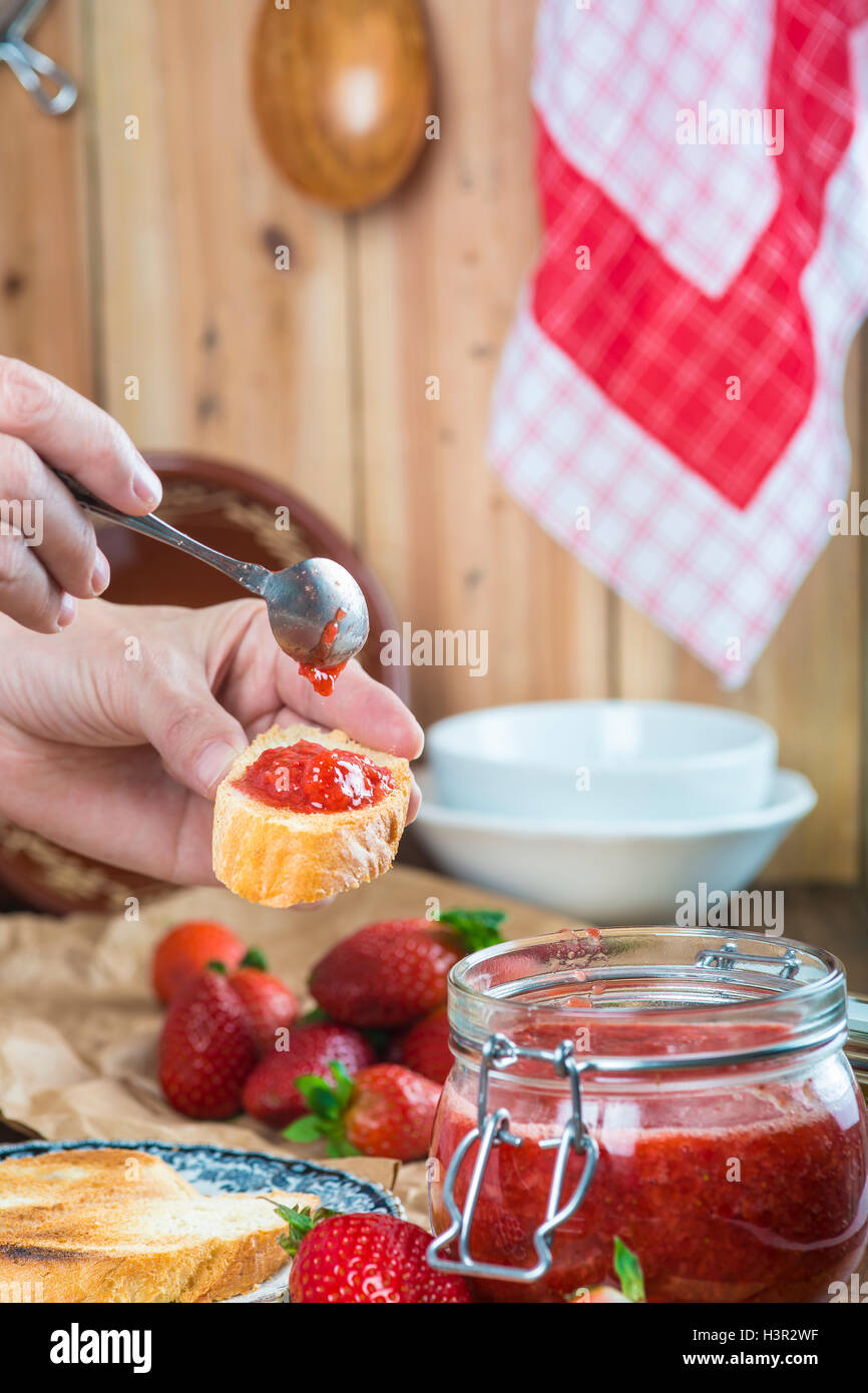 Smearing homemade strawberry jam on a toast for breakfast Stock Photo ...