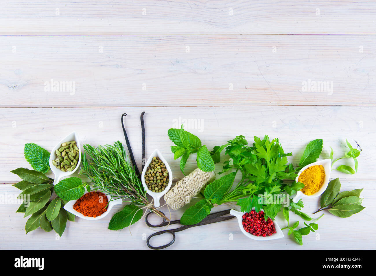 Fresh and colorful herbs and spices assortment on a white wooden ...