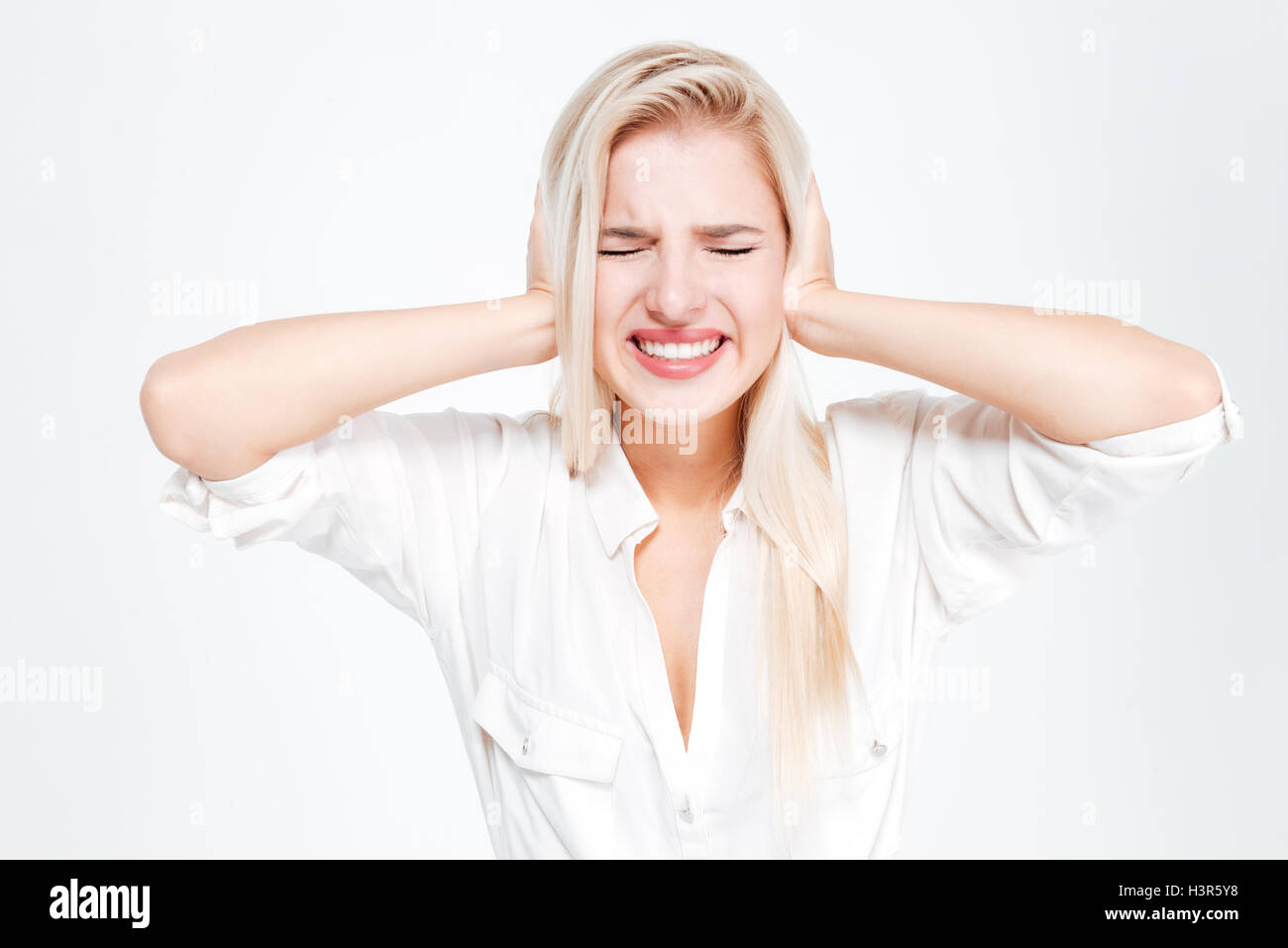Young businesswoman covering her ears and shouting with eyes closed ...