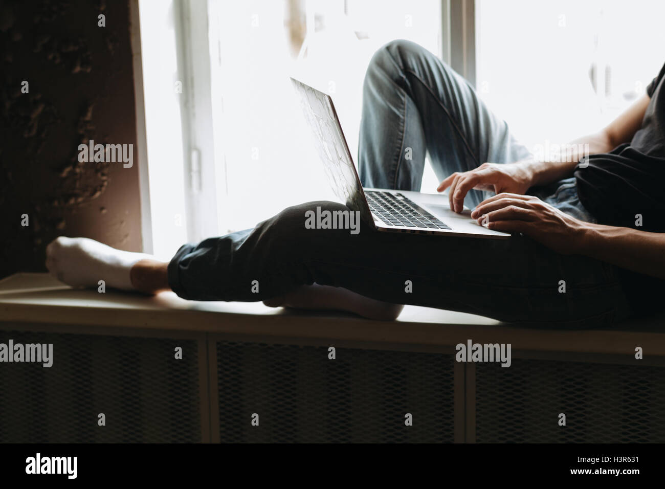 Young man typing something on a laptop Stock Photo - Alamy