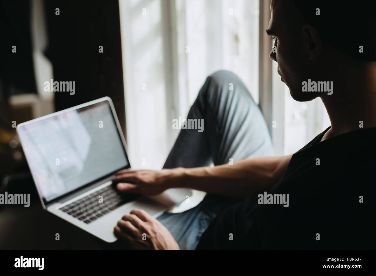 Young man typing something on a laptop Stock Photo - Alamy