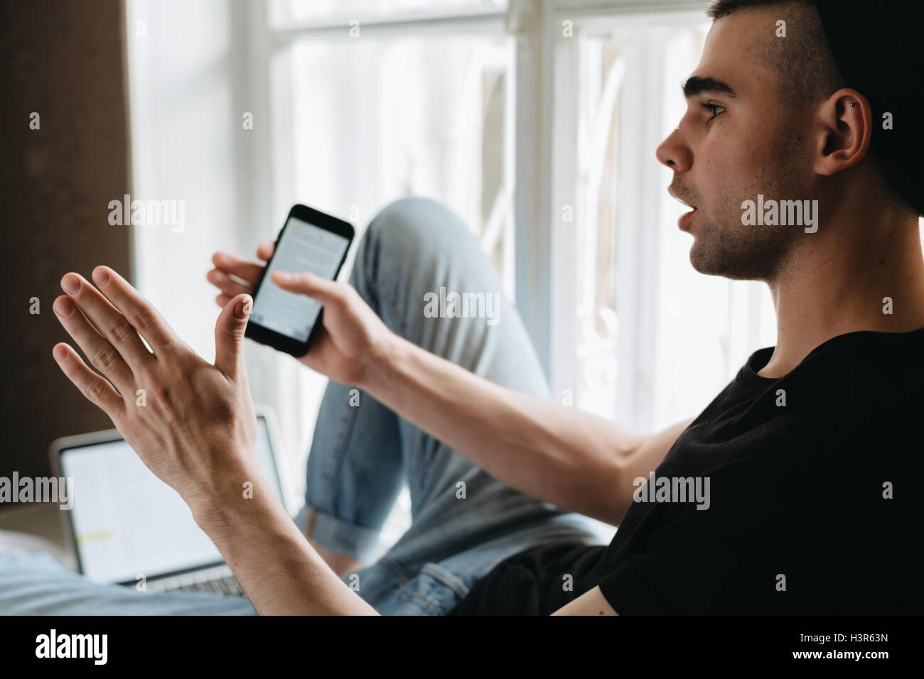 Man explaining something holding mobile Stock Photo - Alamy