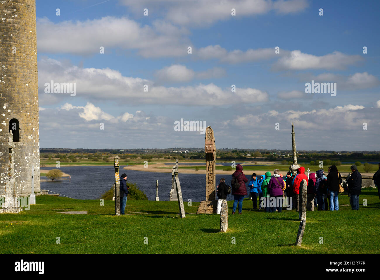 Tourists Stone round tower high cross crosses Clonmacnoise Monastery ...