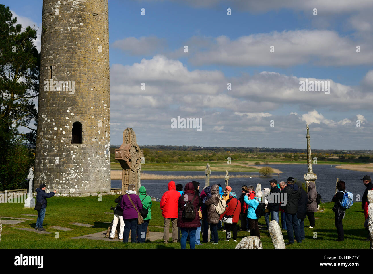 Tourists Stone round tower high cross crosses Clonmacnoise Monastery ...