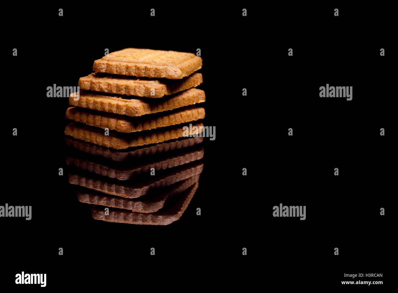 Five biscuits lying on each other isolated on black reflective ...