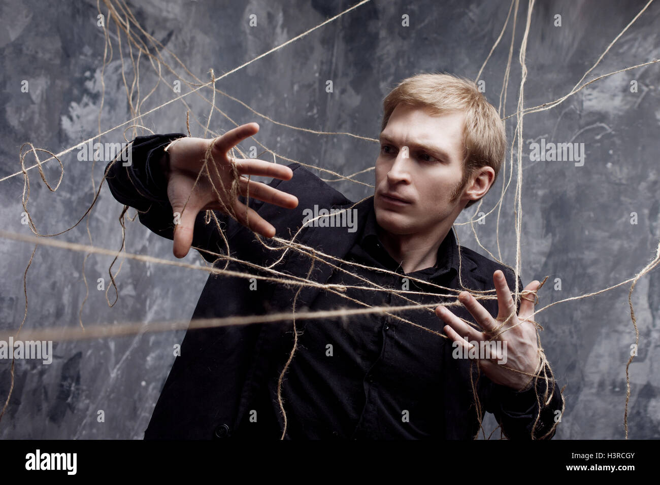 Young man tries to break the shackles. Concept of manipulation and ...