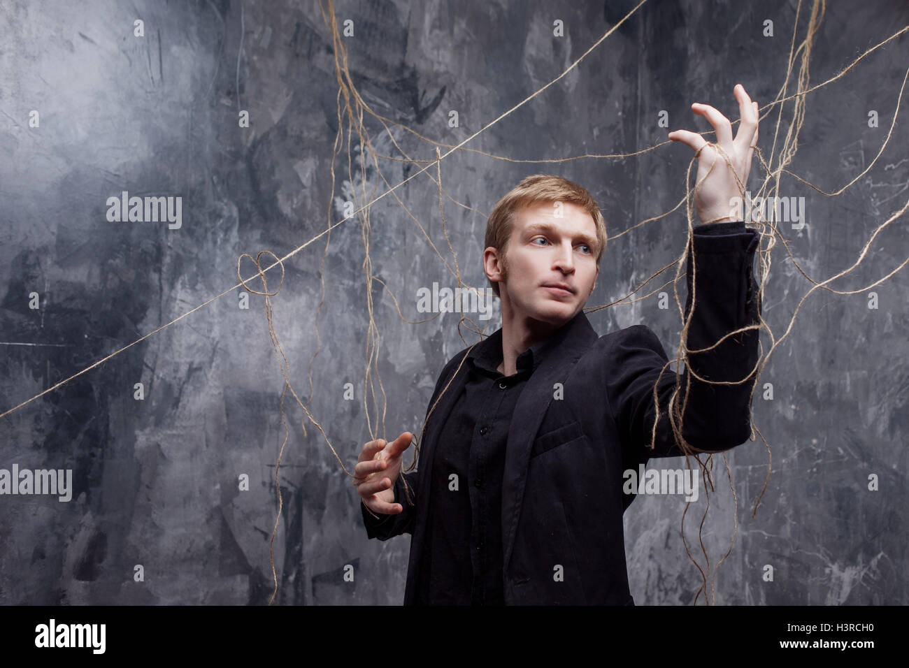 Young man tries to break the shackles. Concept of manipulation and ...