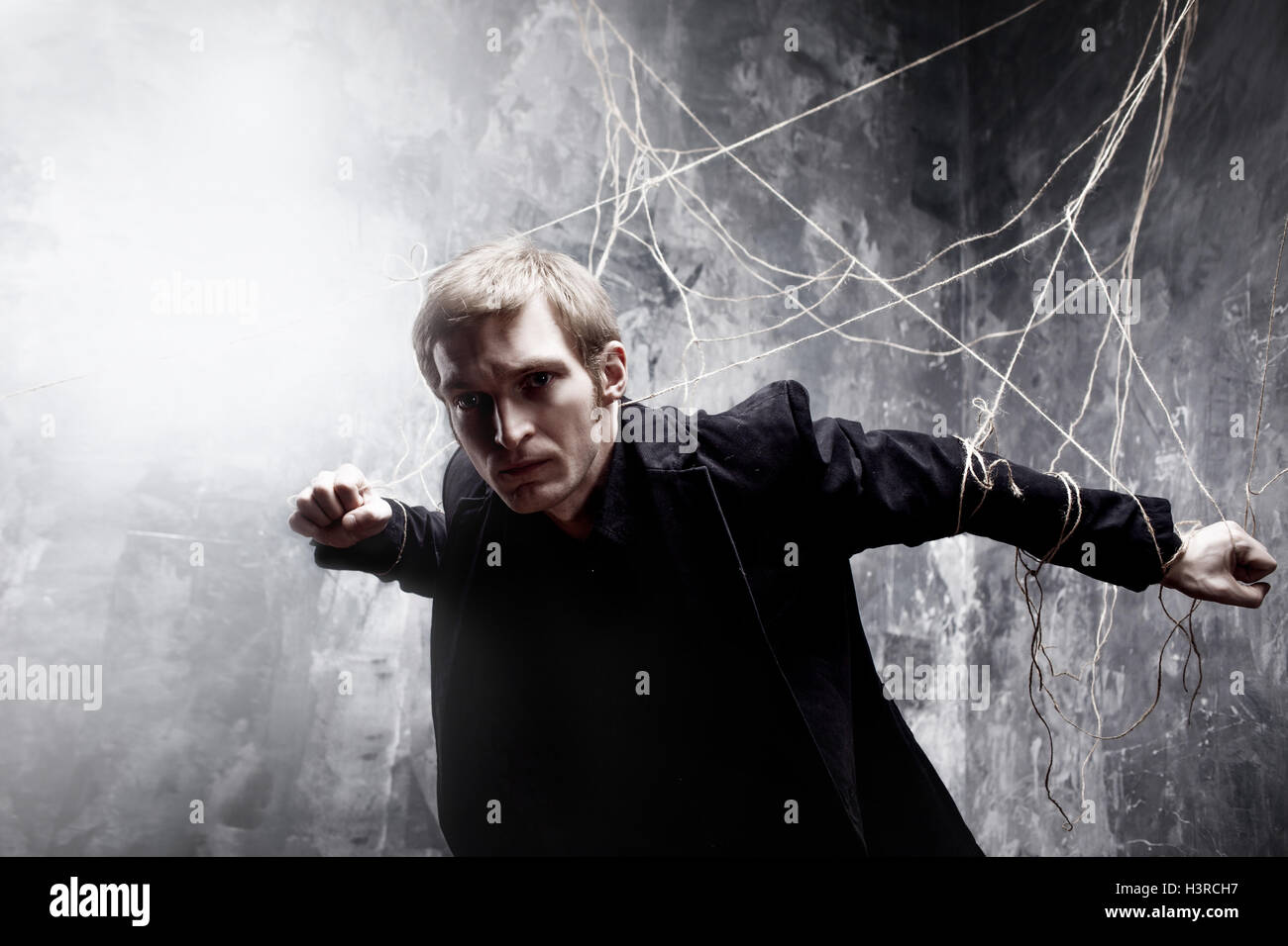 Young man tries to break the shackles. Concept of manipulation and ...