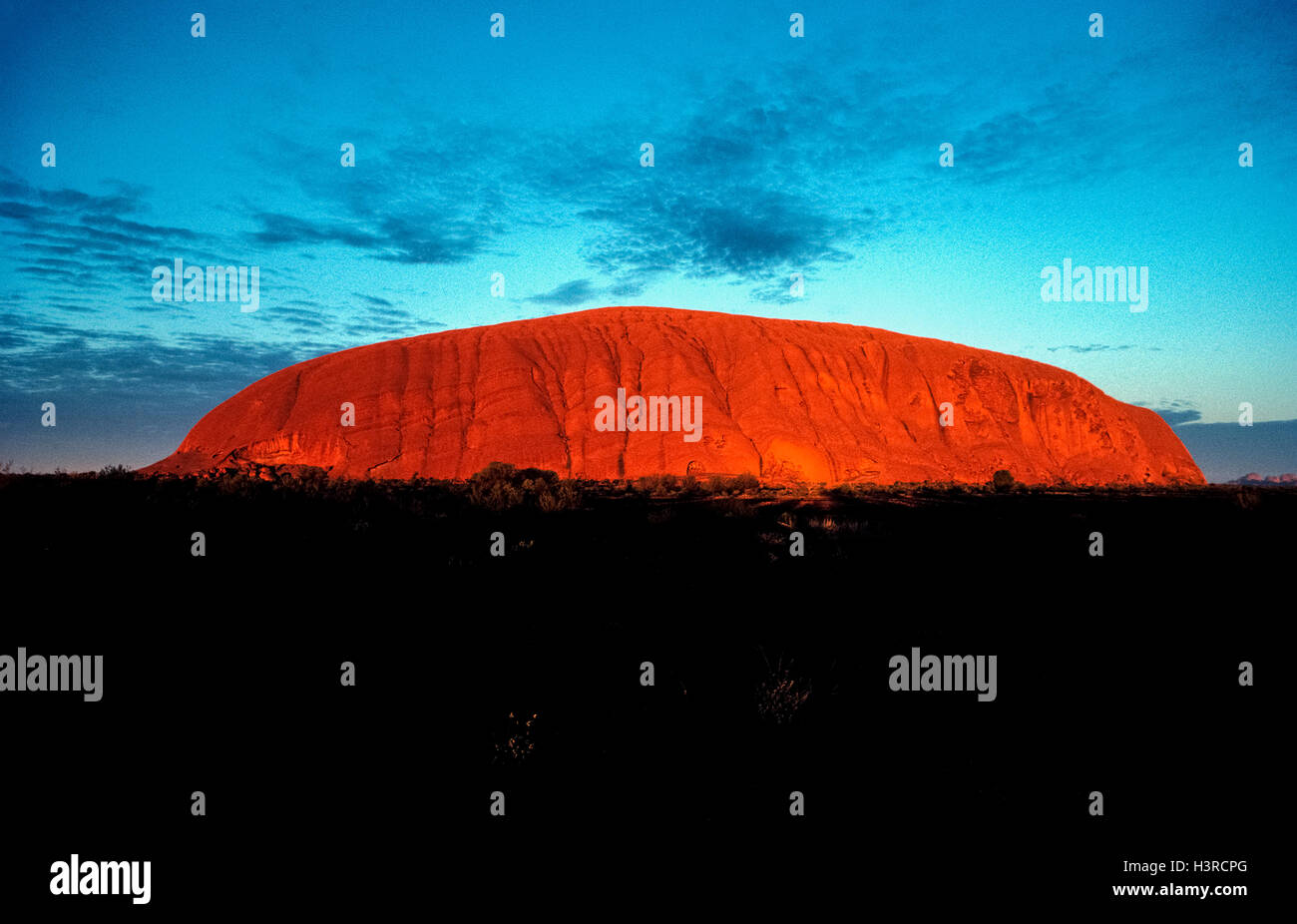 Sunrise on Uluru causes the terra-cotta-colored surface of this world ...