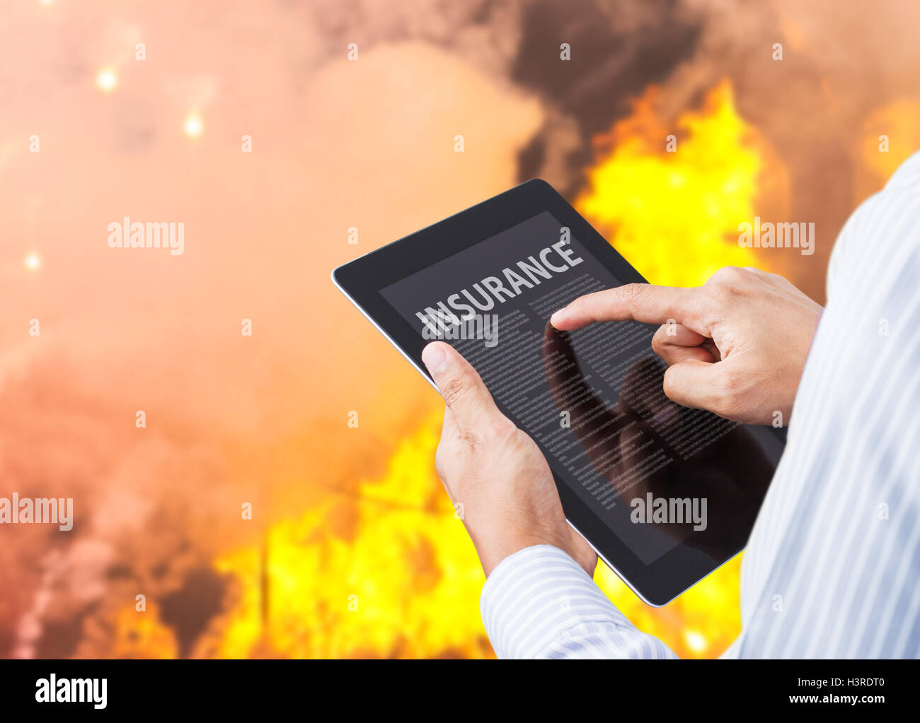 Man pointing at insurance wording on tablet with fire background Stock ...