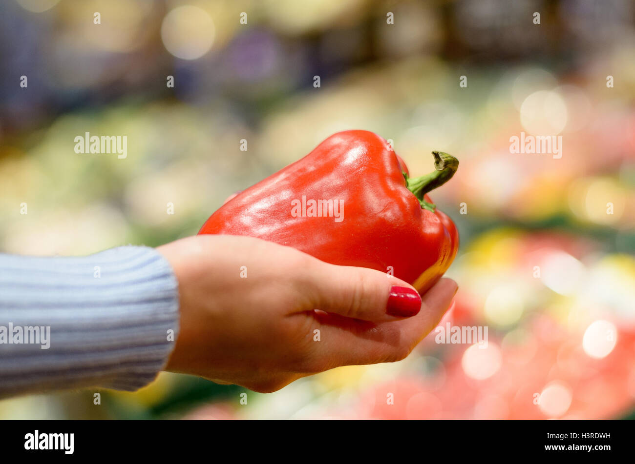 Woman holding a piece of pepper balanced on the palm of her hand at ...