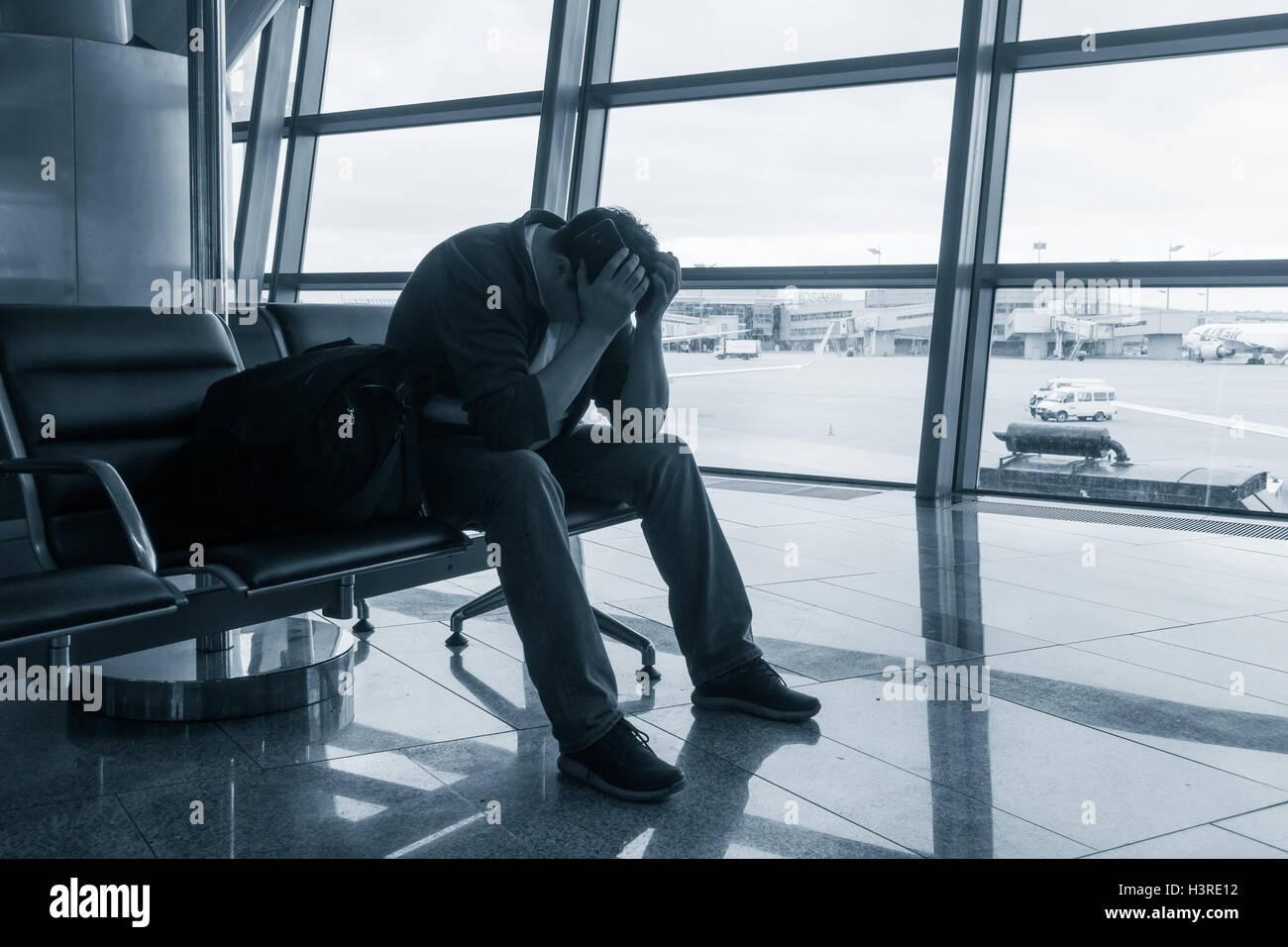Sad man waiting for delayed flight Stock Photo - Alamy