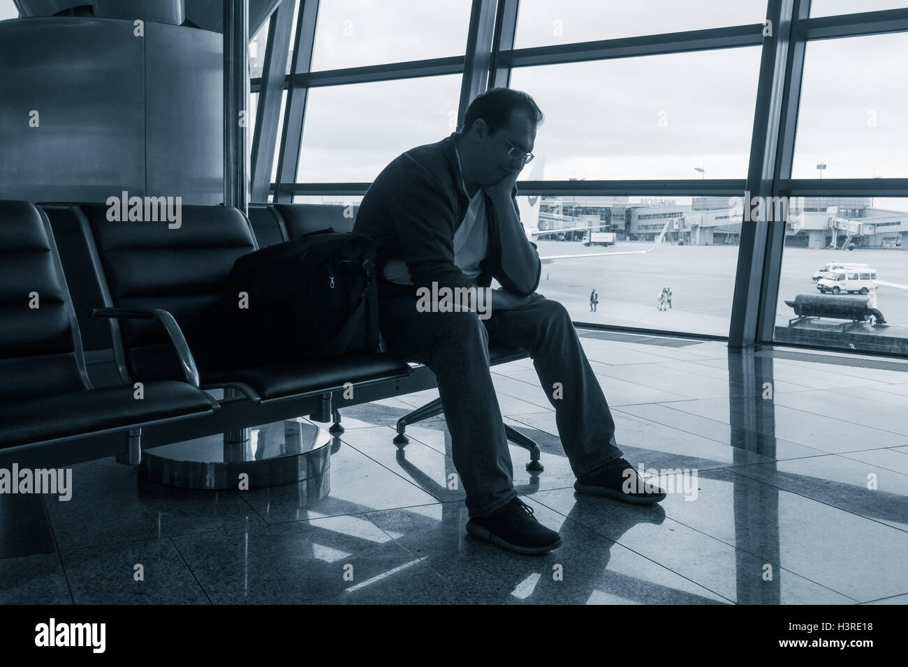 Sad man waiting for delayed flight Stock Photo - Alamy