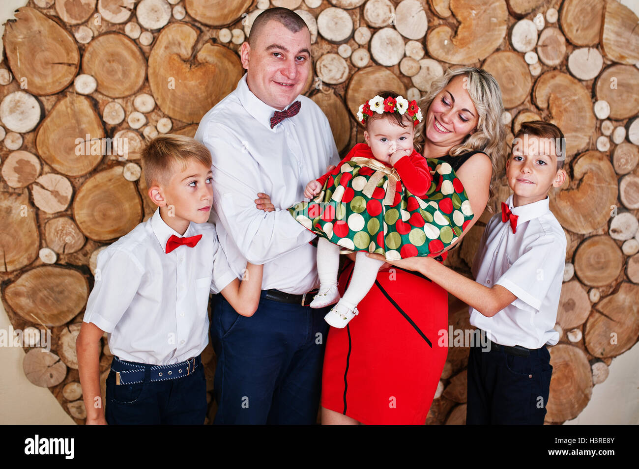 Caucasian family posed in vintage studio room background wooden stump ...