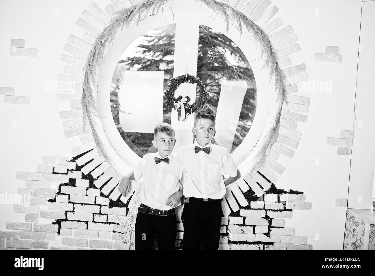 Two brothers posed at studio room background round window Stock Photo ...