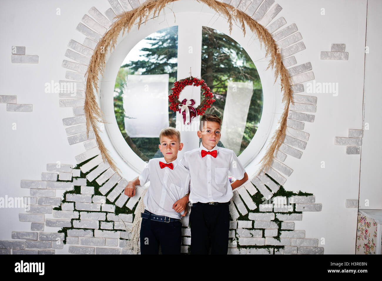 Two brothers posed at studio room background round window Stock Photo ...