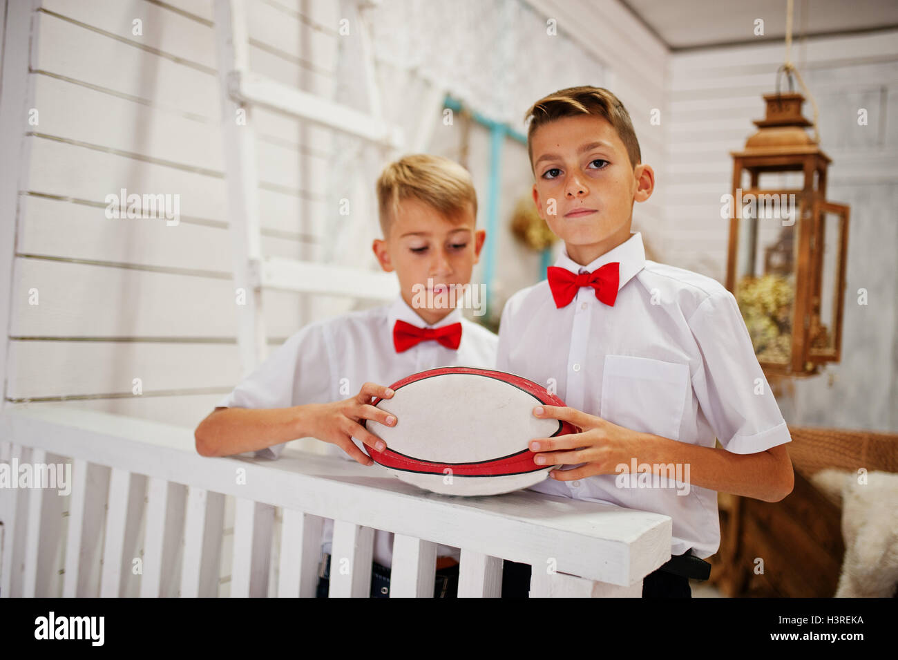 Two brothers posed at studio room and hold a ball for rugby Stock Photo ...