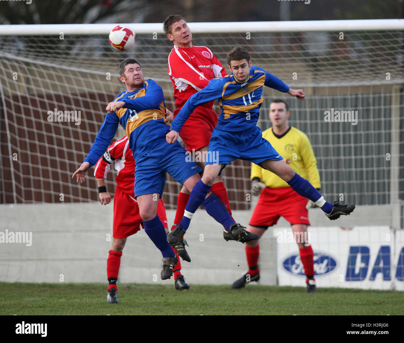 Craig Dennis of Barkingside rises between James Gammons (L) and Paul ...