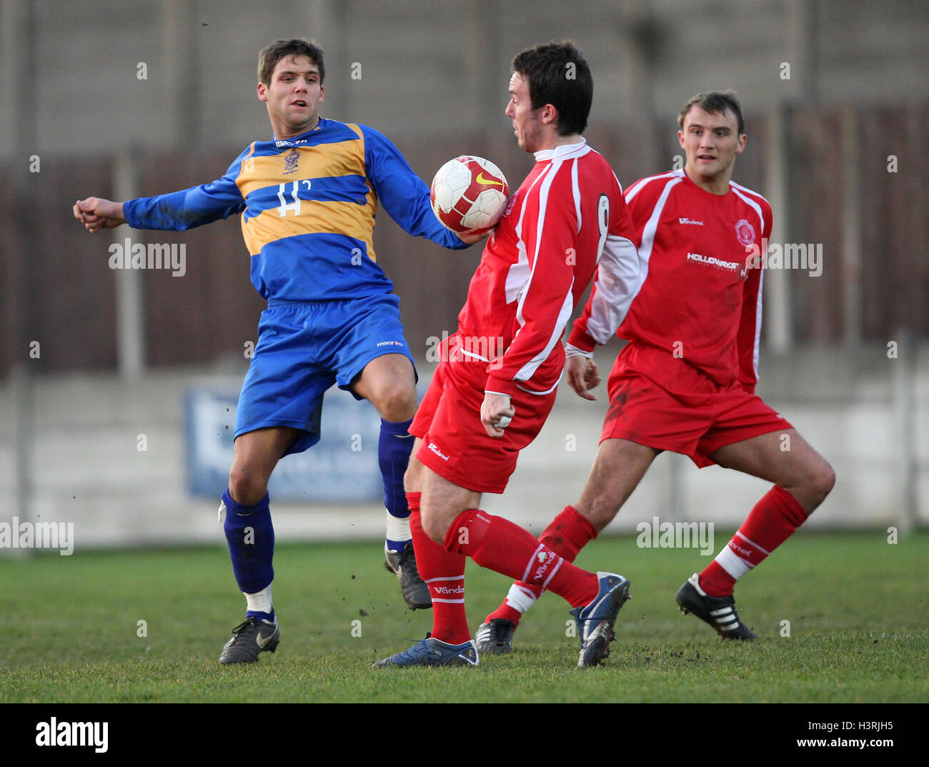 Jimmy Noakes of Romford is beaten to the ball by Gregg Thompson of ...
